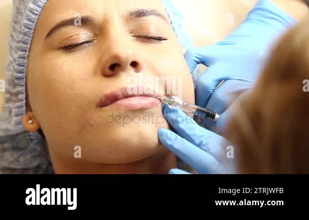 Young woman on lip Augmentation in a clinic. Anesthetic injection ...