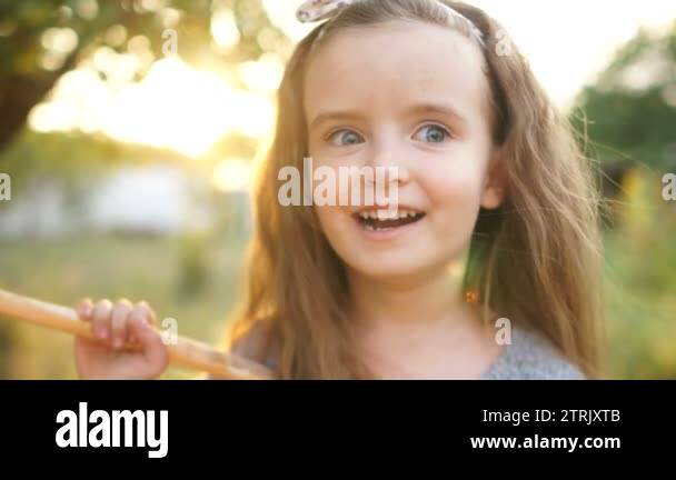 Happy little girl on the meadow in summer day. The long-haired baby ...