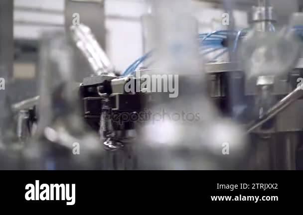 Spill of alcohol in glass bottles at the plant. Conveyor belt with ...