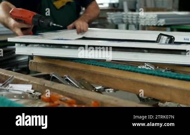 Production and manufacturing of pvc windows, a male worker assembles a ...