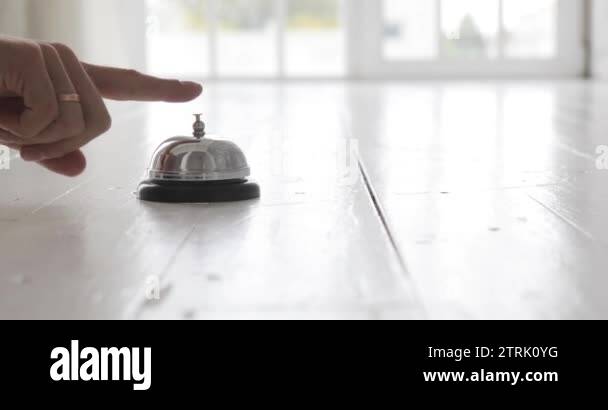 Modern luxury hotel reception counter desk with bell - Hand strikes the ...