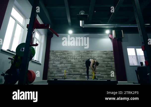 Medium shot slow mo tilt-down tilt-up men exercising and lifting ...