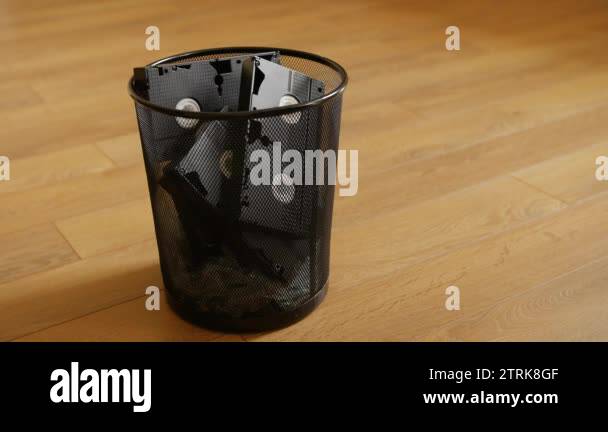 Stack of VHS video tapes dispose of in the trash over wooden background ...