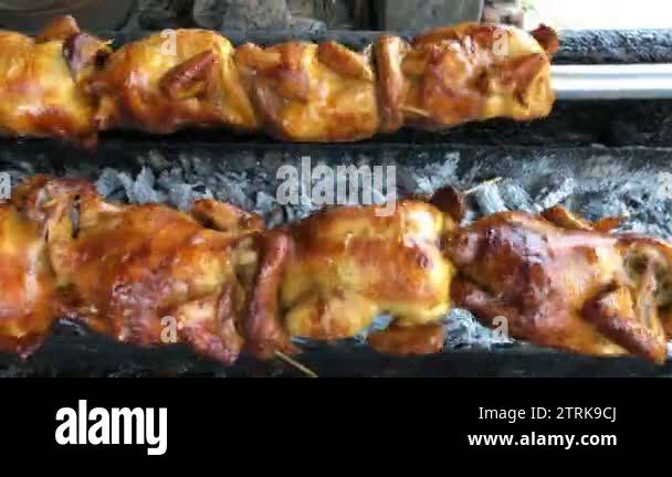 Roasted full body chicken with spin on the stove on street food in ...
