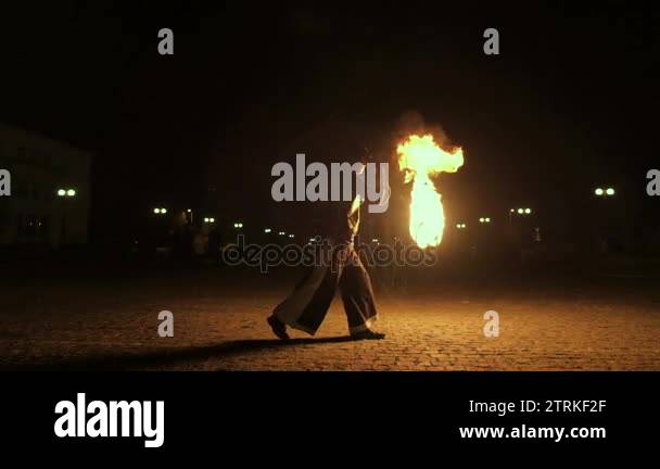 Fire show performance. Handsome male fire juggler performing contact ...