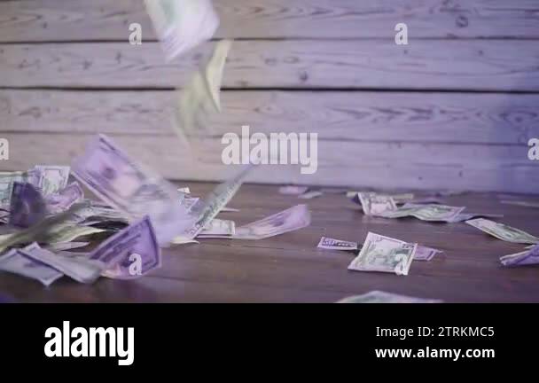 dollar bill notes falling through the air on a wooden floor and a wall ...