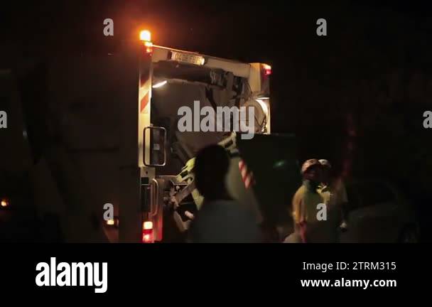 Night cleaning of garbage by workers on the garbage truck. Cala Mendia ...