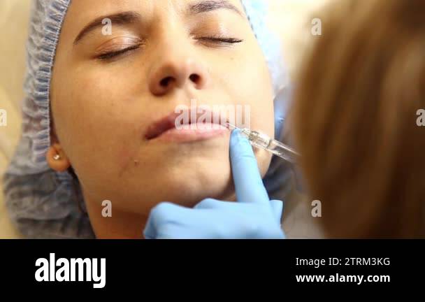 Young woman on lip Augmentation in a clinic. Anesthetic injection ...