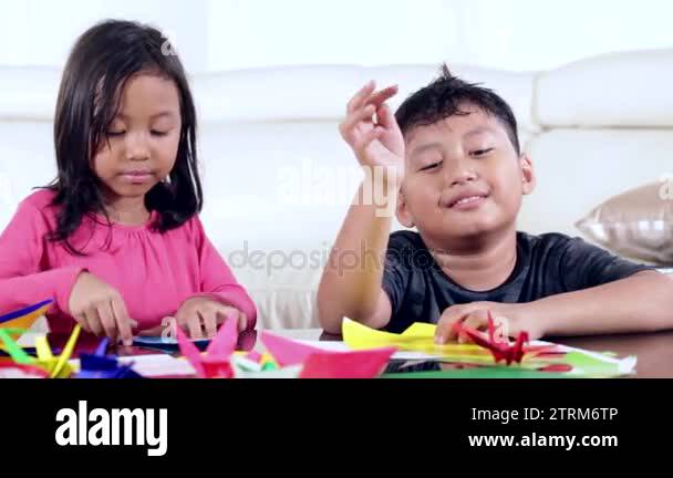 Two children playing origami paper Stock Video Footage - Alamy
