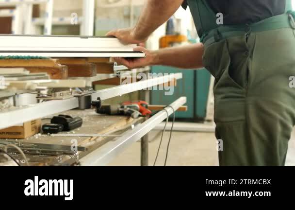 Production and manufacturing of pvc windows, male worker produces pvc ...