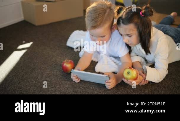 Happy siblings child using pc tablet together. Brother and sister play ...
