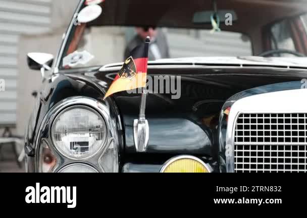 The man of a representative kind closed the trunk of a retro car. A ...