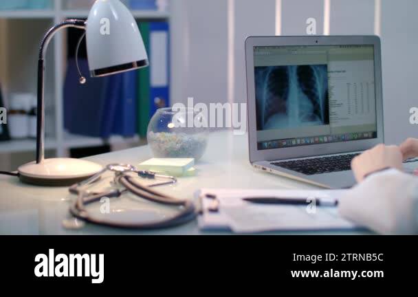 Doctor working with xray on laptop at workplace. Radiologist check x ...