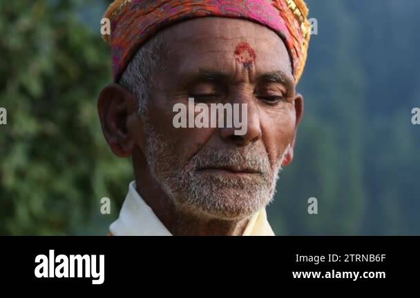 A Hindu old man in yellow offering special spiritual prayer to god ...
