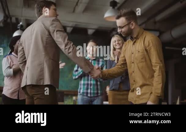 Two partners, businessman shake hands. Group of people clapping on a ...