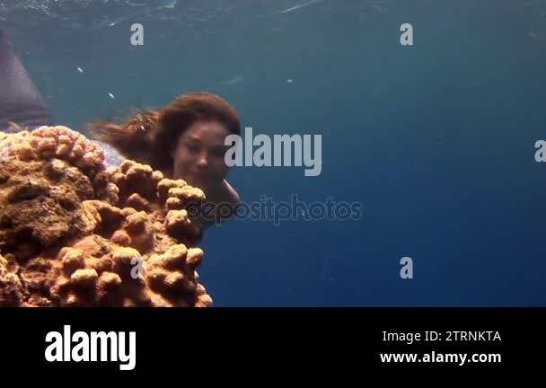 Underwater model free diver swims in clean transparent blue water in ...