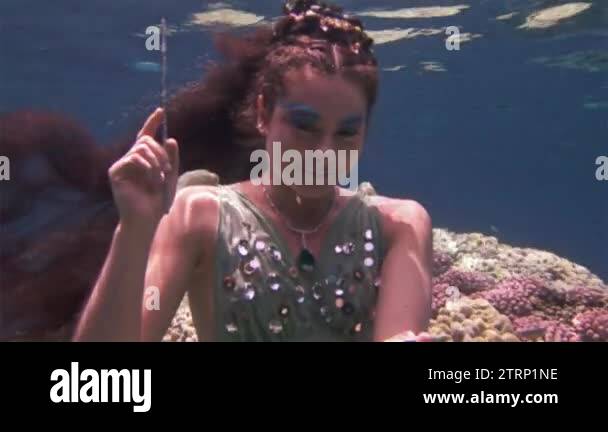 Underwater model free diver in fairy costume on background of corals in ...