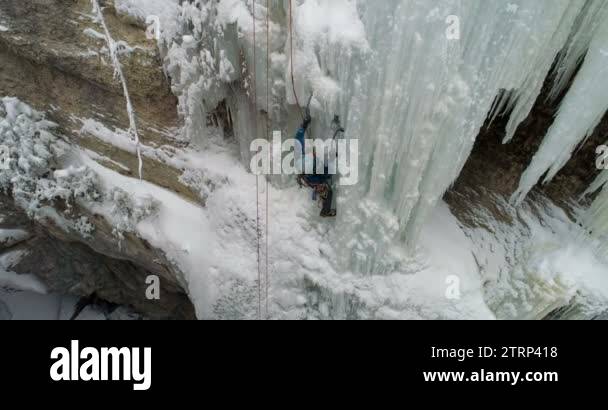 Overhead of ice climber climbing frozen cliff during winter 4k Stock ...