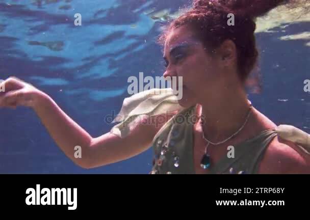 Underwater model free diver poses for camera on background of corals in ...