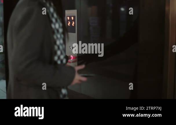 Woman press the button in the elevator and wait. Female standing in ...