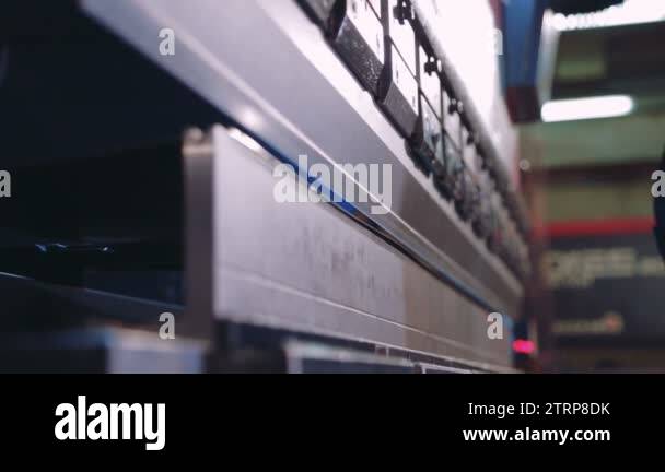 Worker bend metal sheet on a modern bending industrial machine at a ...