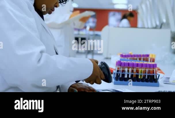 Laboratory technician scanning invoices with barcode scanner in blood ...