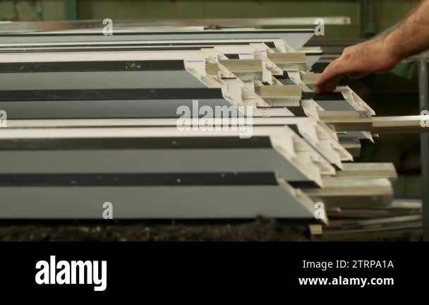 Manufacturing windows pvc, male worker inserts a metal profile into the ...