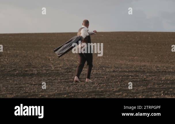 Bearded man in a suit in the field barefoot. Male in a classic costume ...