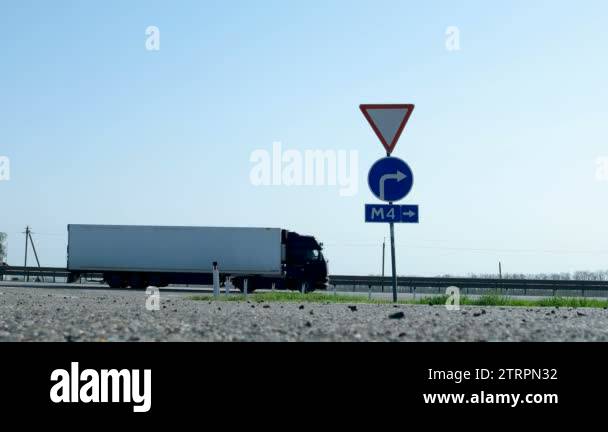 Road sign - entrance to the toll highway M4 Don. Trucks and cars pass ...