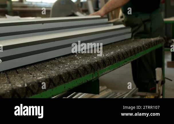 Manufacturing windows pvc, male worker inserts a metal profile into the ...