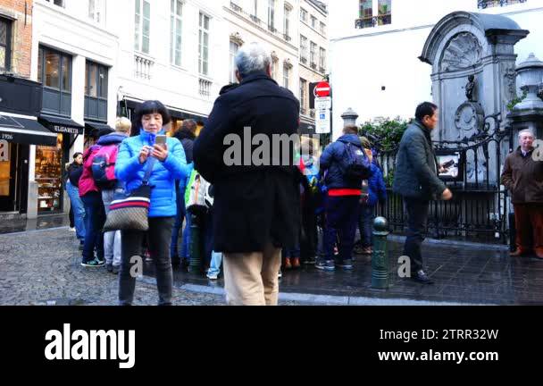 tourists are photographed near the sculpture of the "Manneken Pis Stock ...