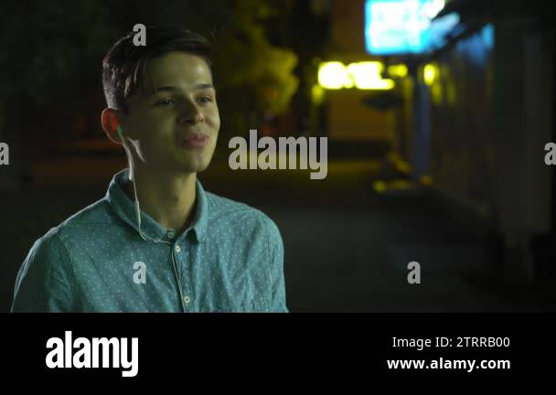 Sportive young man is eating cookies and smiling happily in a street at ...