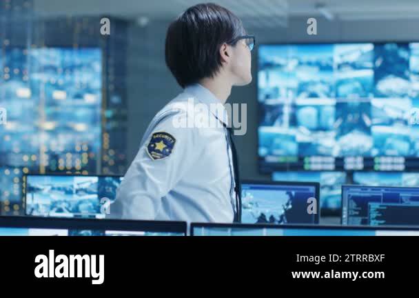 In the Security Control Room Officer Monitors Multiple Screens for ...