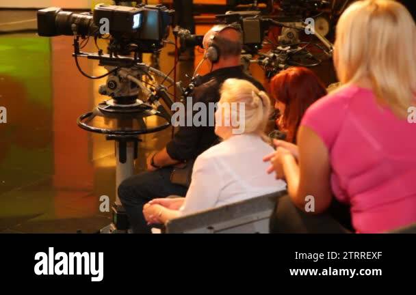 Back view of spectators and cameraman in TV studio during filming Stock ...