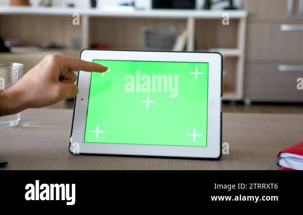 Close up man hands touching a digital talbet PC with green screen ...