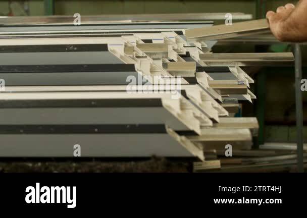 Manufacturing windows pvc, male worker inserts a metal profile into the ...