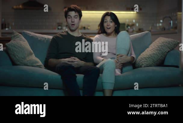 Man and woman watching tv with shocked expressions on their faces Stock ...