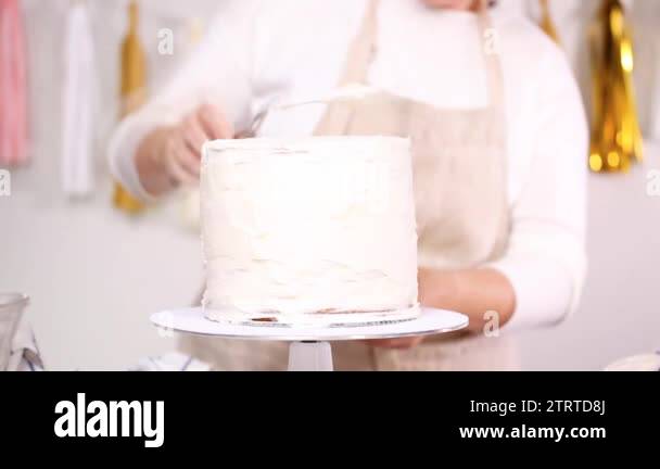 Step by step. Pastry chef stacking cake layers with buttercream ...