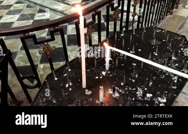 Woman lighting prayer candle aka offering, sacrificial or memorial ...