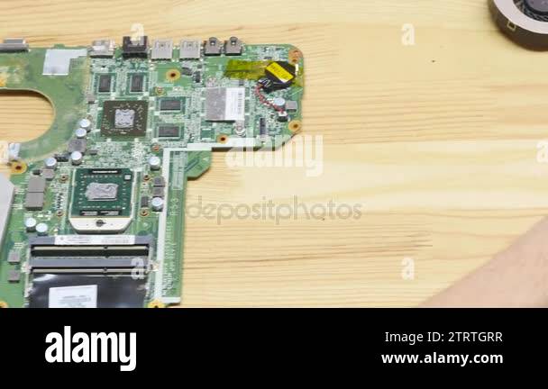 Laptop disassembling in repair shop, close-up. Disassembled computer motherboard on repairman ...