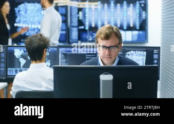 Neural Network Algorithm Architect Working at His Workstation in a Busy ...