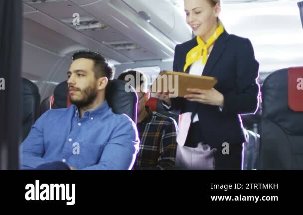 Airplane Stewardess/ Flight Attendant Shows Tablet Computer with Menu ...