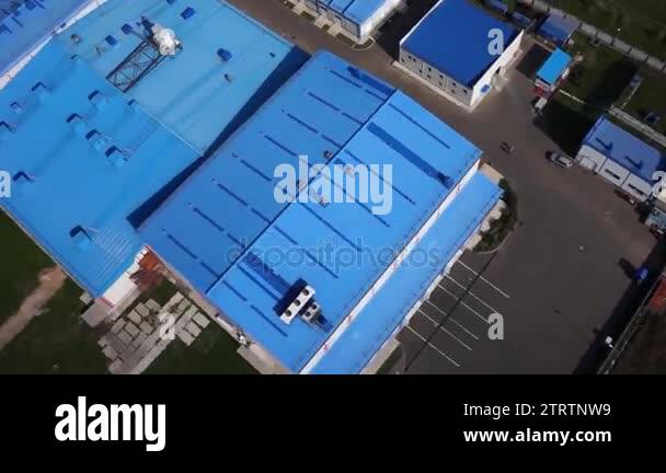 Flying over the factory with blue roof. aerial view of sewage treatment ...