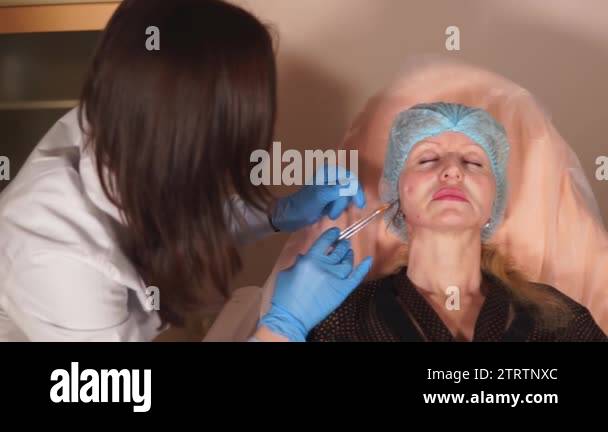 Shot of the doctors arm who put the injection implant under the skin of ...