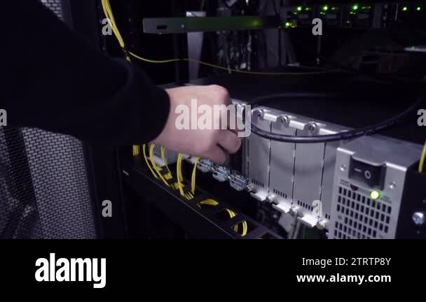 IT engineer working in a data center with rows of server racks and ...