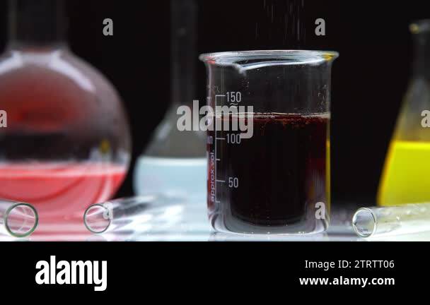 Different types of chemical laboratory glassware with liquids inside ...