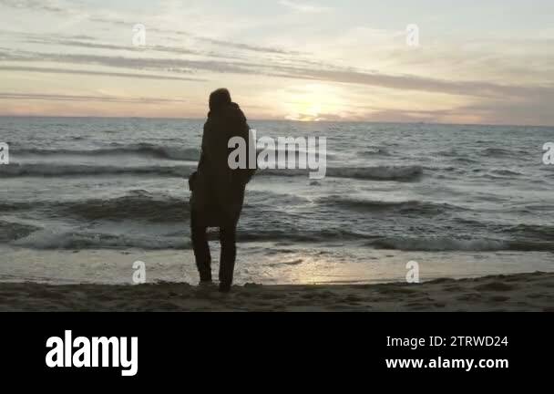 Sad man runs on the shore of the sea and throws sand. Beautiful ...