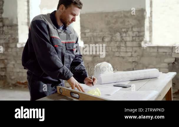 Building object. The master at the table with the drawing. The man ...