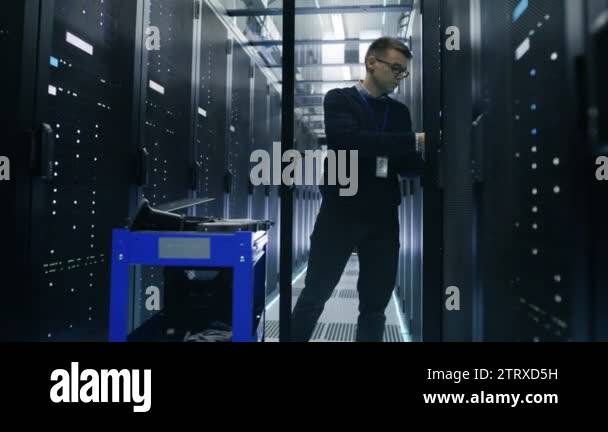 Server Engineer Changes Hard Drives in Open Cabinet of Rack Server. He ...