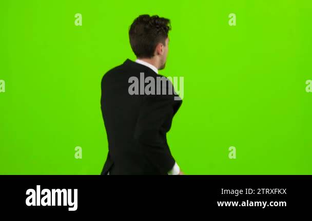 Man is a telephone rings to him and he talks. Green screen. Back view ...